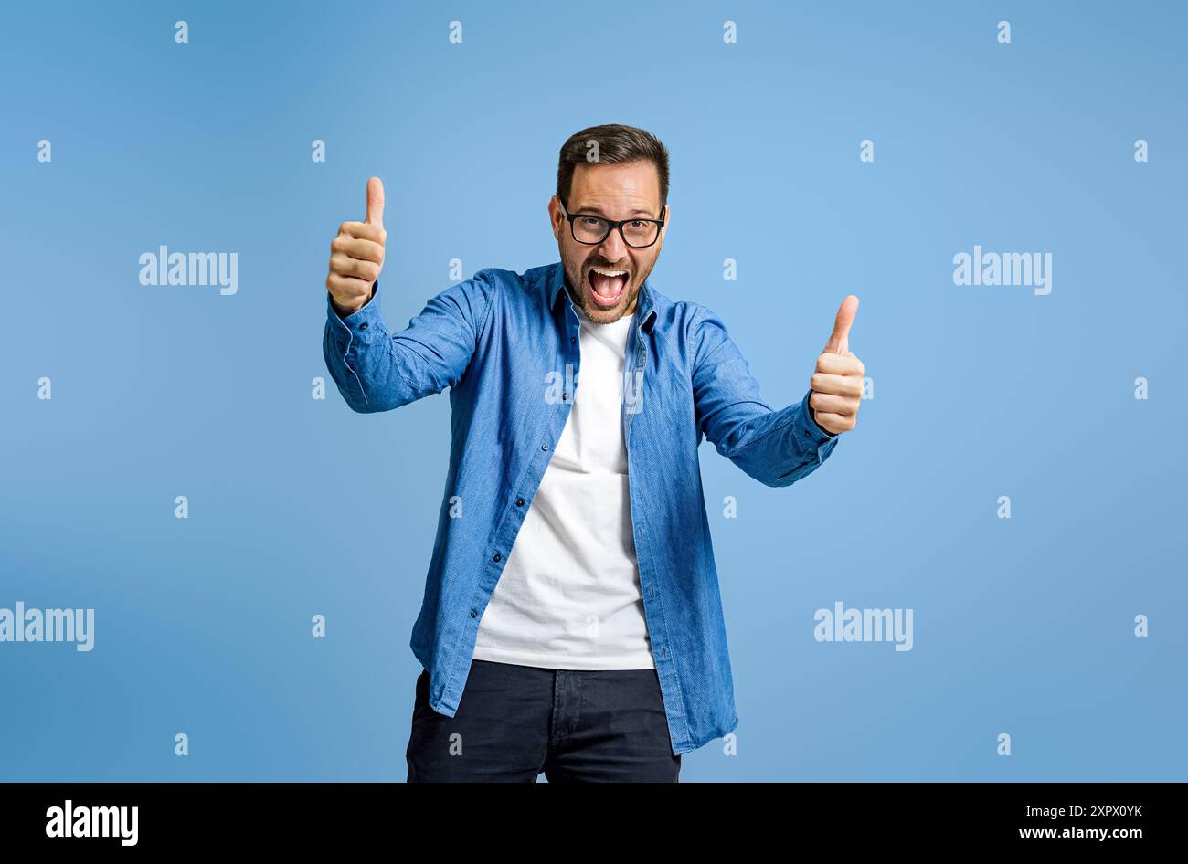 Successful businessman showing thumbs up and shouting ecstatically ...