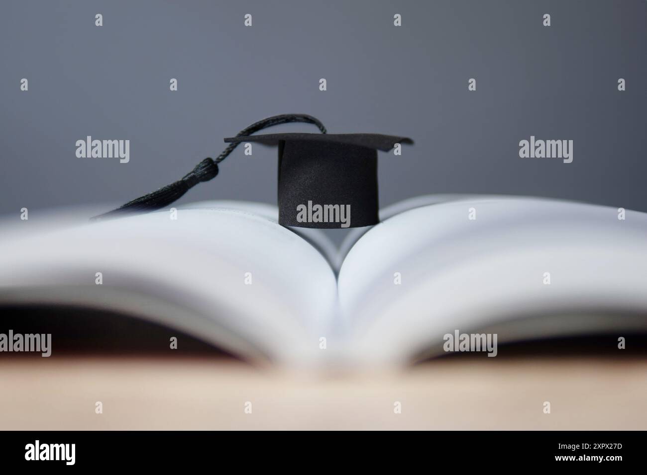 A black graduation cap on an open book. Education, knowledge concept ...