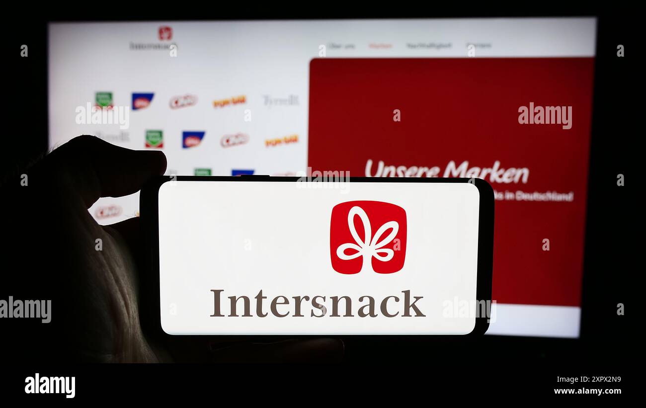 Person holding cellphone with logo of German snack food company ...