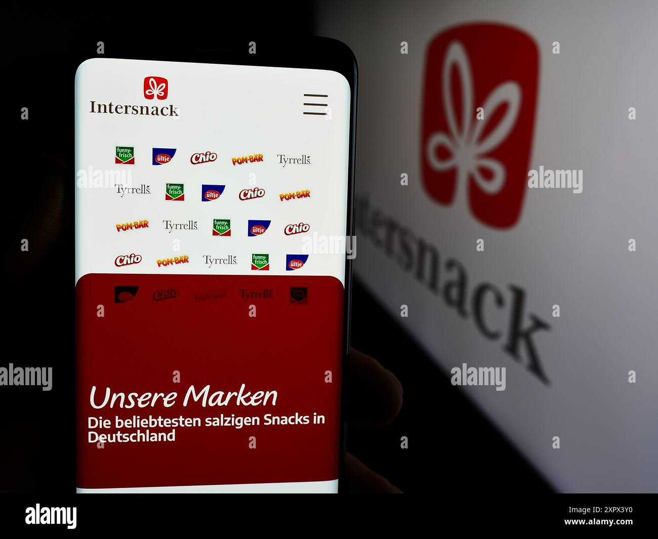 Person holding smartphone with webpage of German snack food company ...