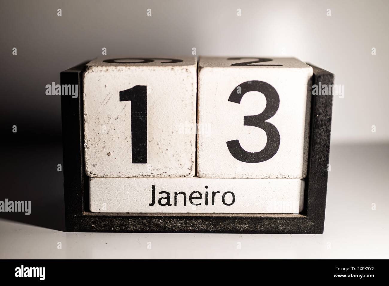A close-up of a wooden block calendar displaying the 13th of January ...