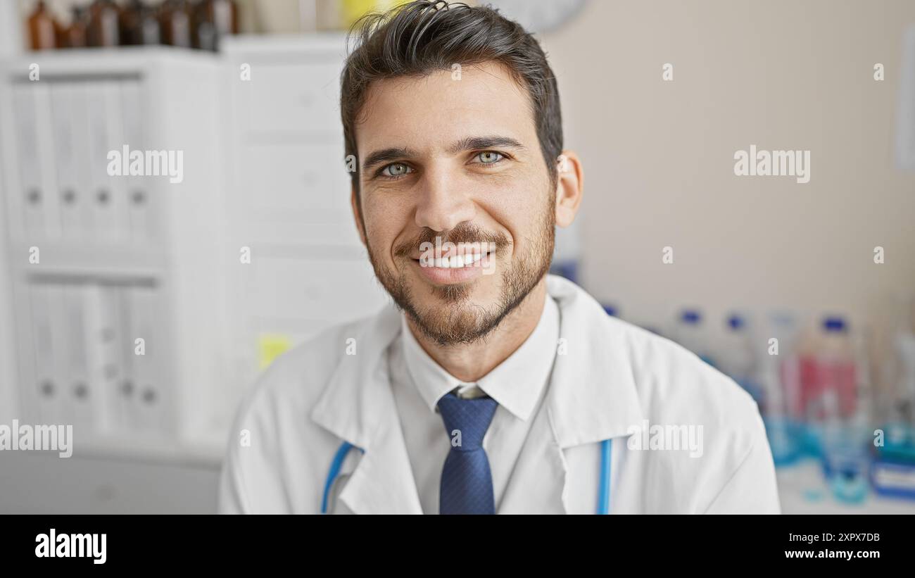 Handsome young hispanic man with beard wearing lab coat in medical ...