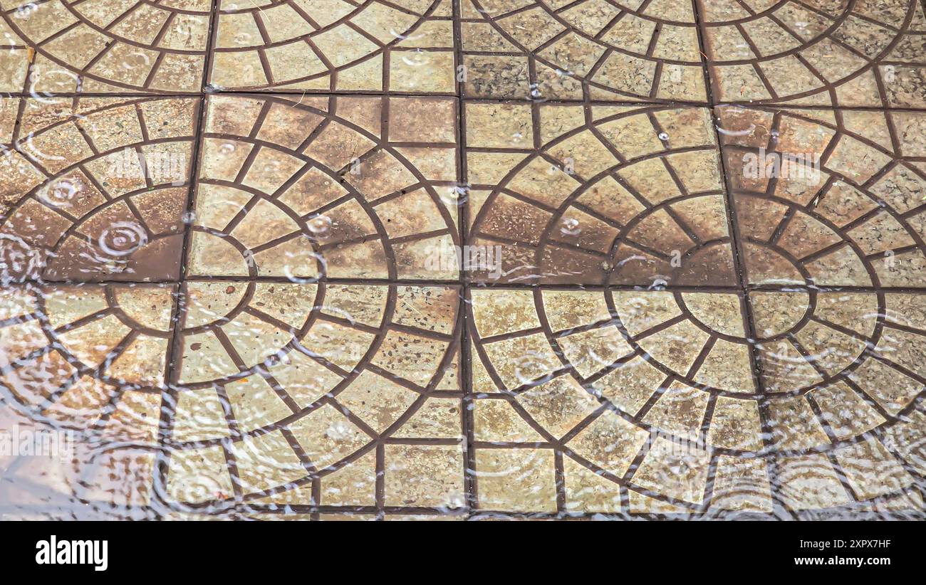 Street tiles wet from rain. Different textures of stone. Large drops ...