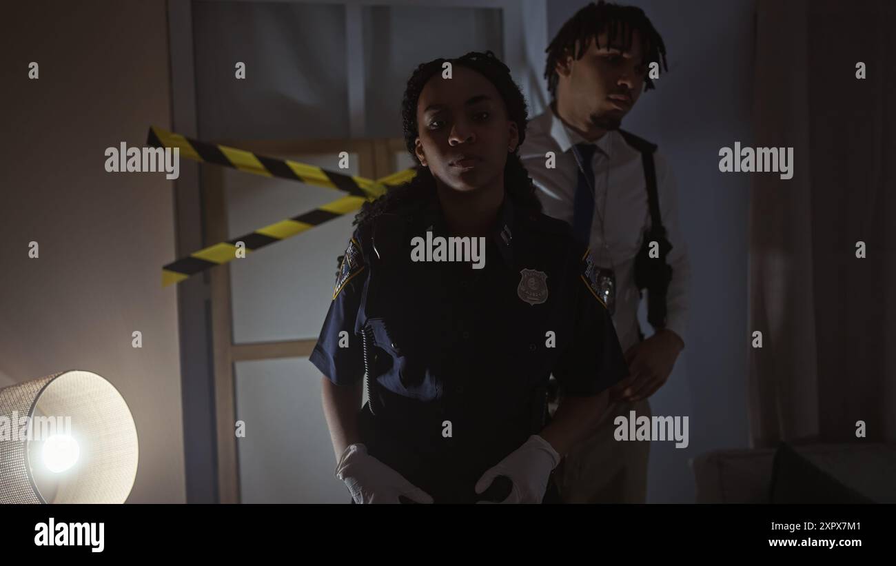 Policewoman and man investigating a dimly lit indoor crime scene Stock ...