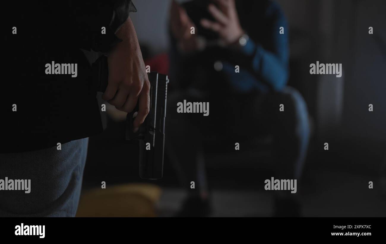 A suspicious man handcuffed on a sofa indoors, a policewoman standing ...