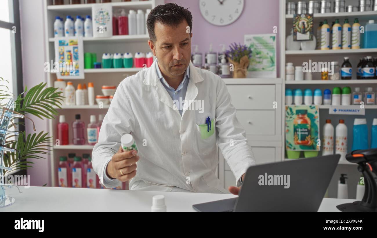 Hispanic man examining a medicine bottle while using a laptop in a ...