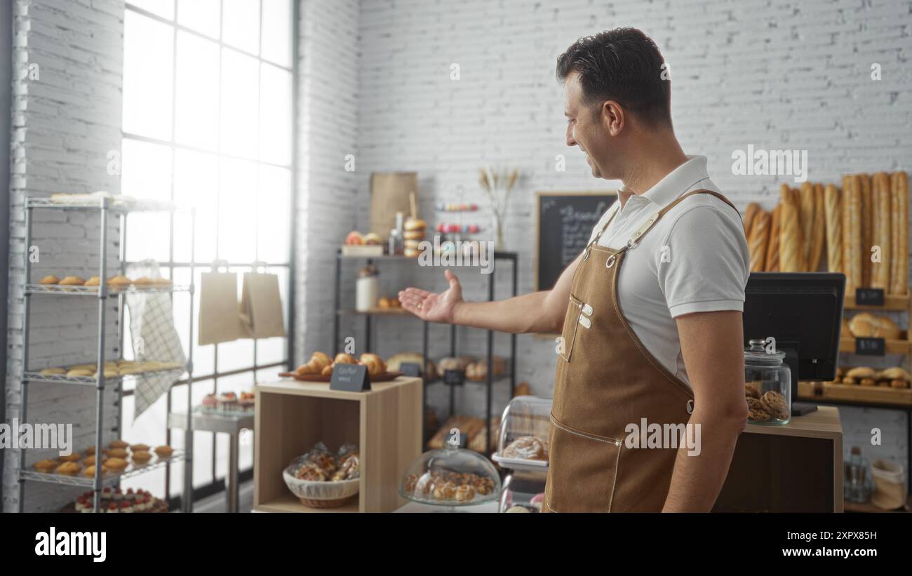 Hispanic, middle-aged man presenting bakery goods inside a well-lit ...