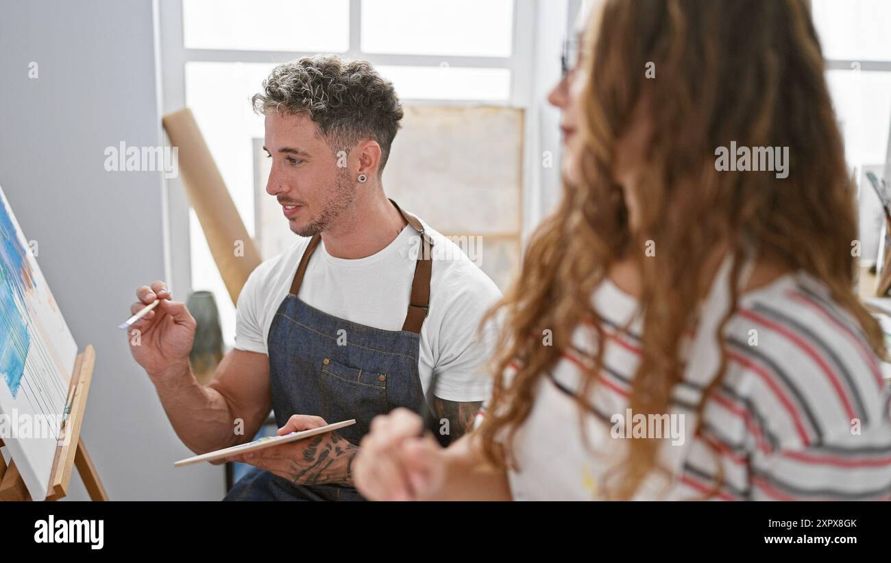 Creative man and woman painting on canvas in a light-filled studio ...