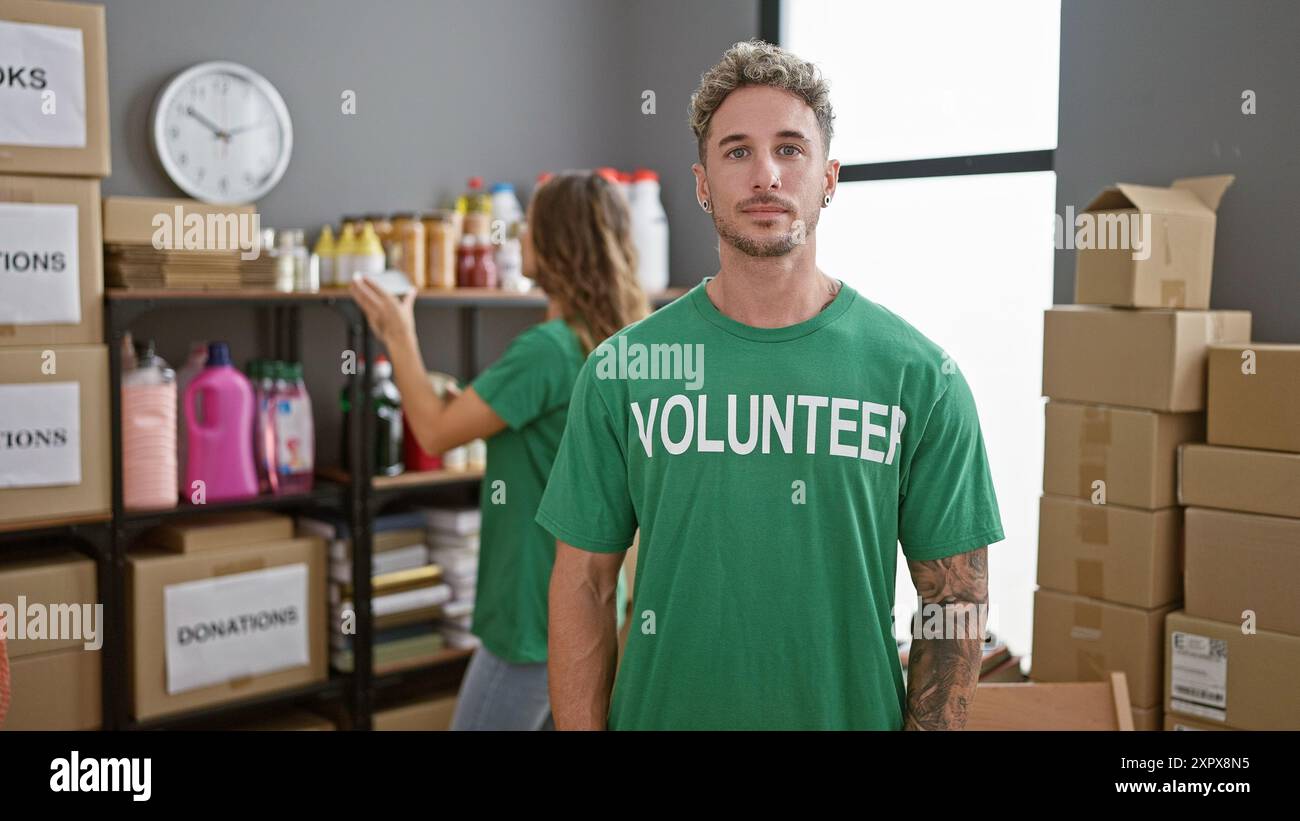 Young man and woman volunteers organizing donations in a warehouse ...