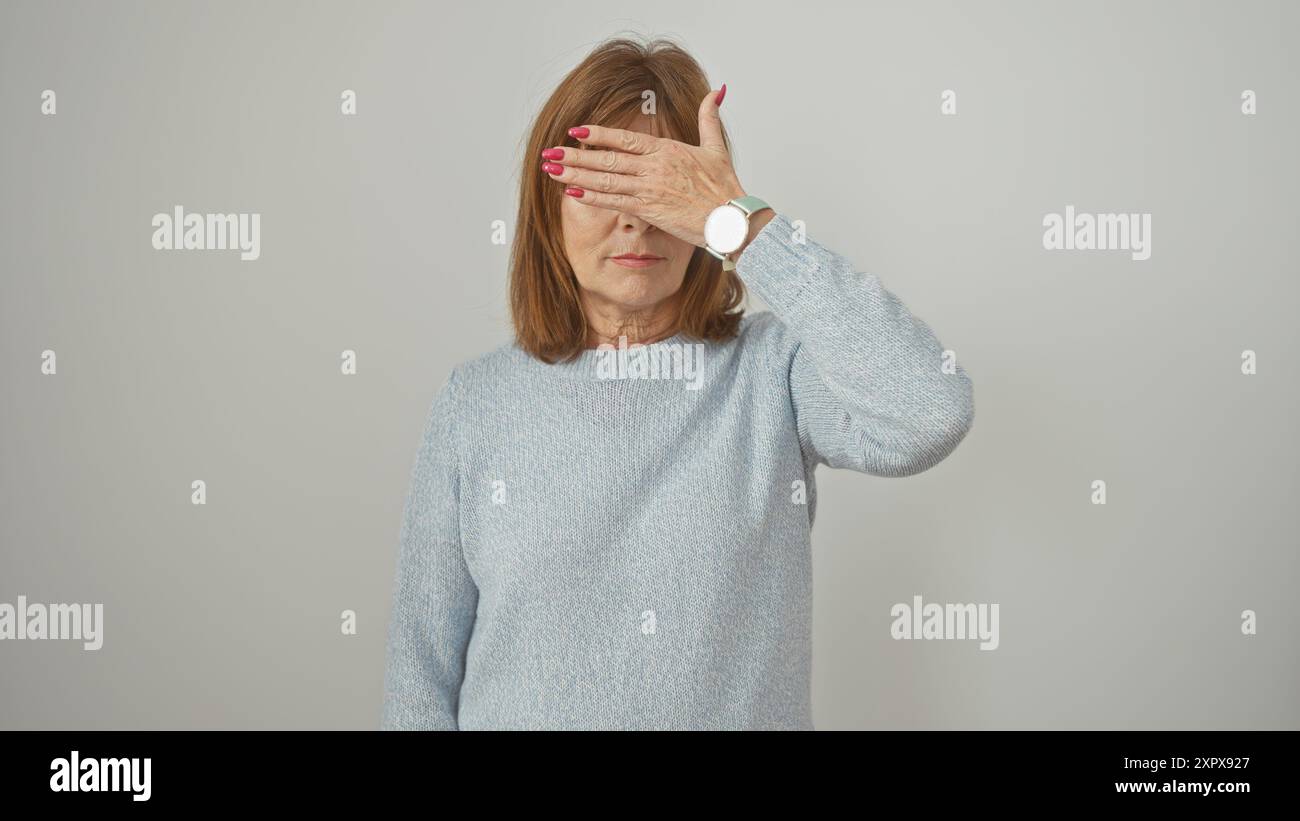 Middle-aged woman with short hair covering face against white ...
