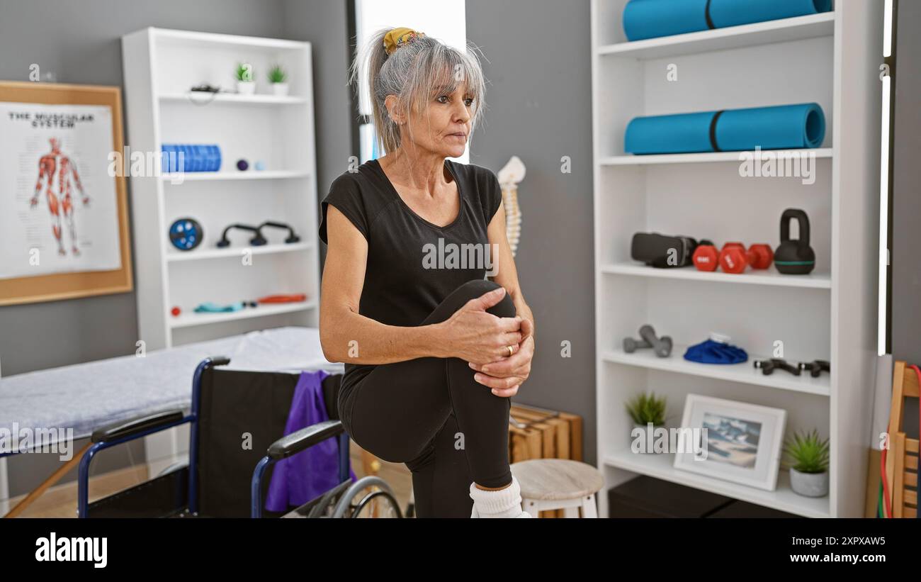 Mature hispanic woman exercises in rehab clinic room, rehabilitation ...