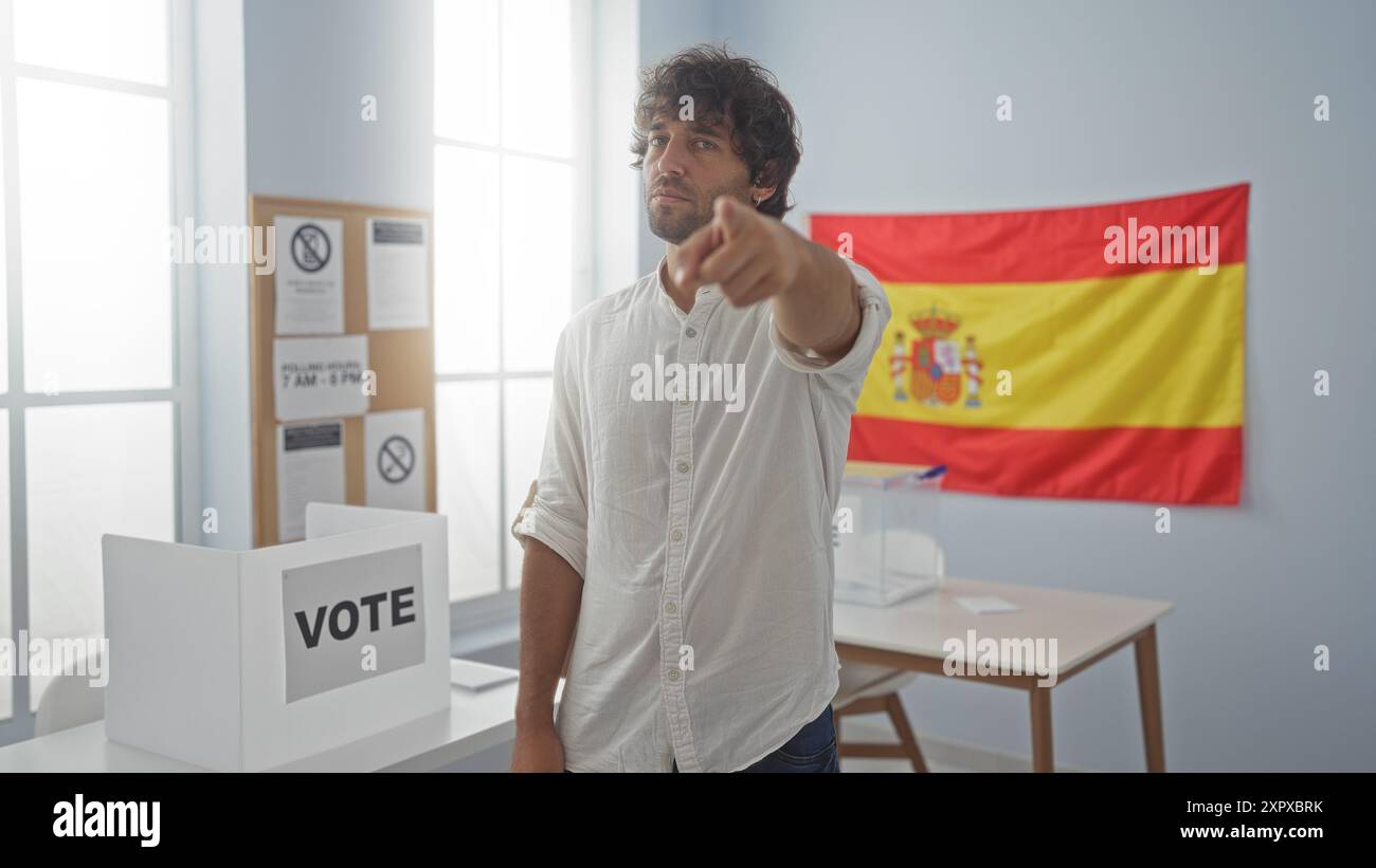 Young man pointing in a spanish electoral college room with voting ...