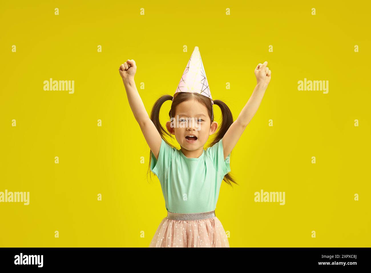 Excited Child Girl Celebrating Holiday in Party Hat, Cheerfully Raised ...