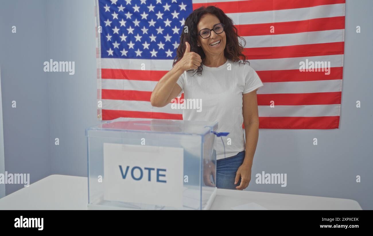 Woman voting in an indoor polling station with an american flag in the ...