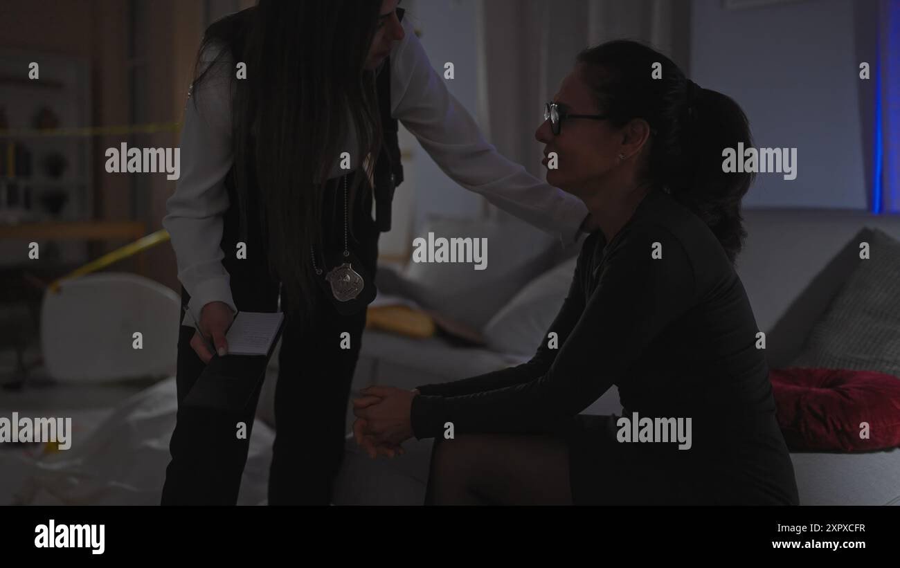 A policewoman investigates a female suspect in a dimly lit indoor crime ...
