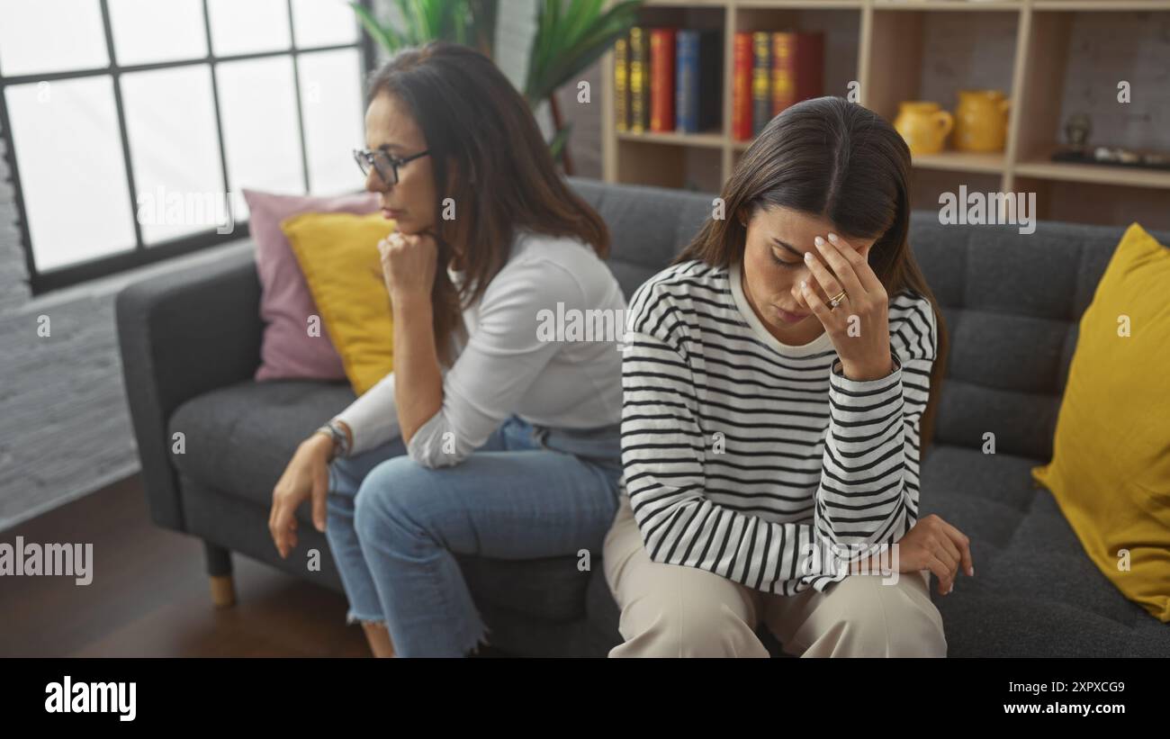 Two worried women in a modern living room, suggesting a mother and ...