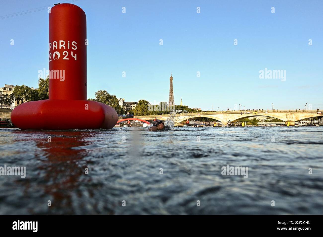 Athletes swim in the Seine River around a buoy, as they compete in the ...