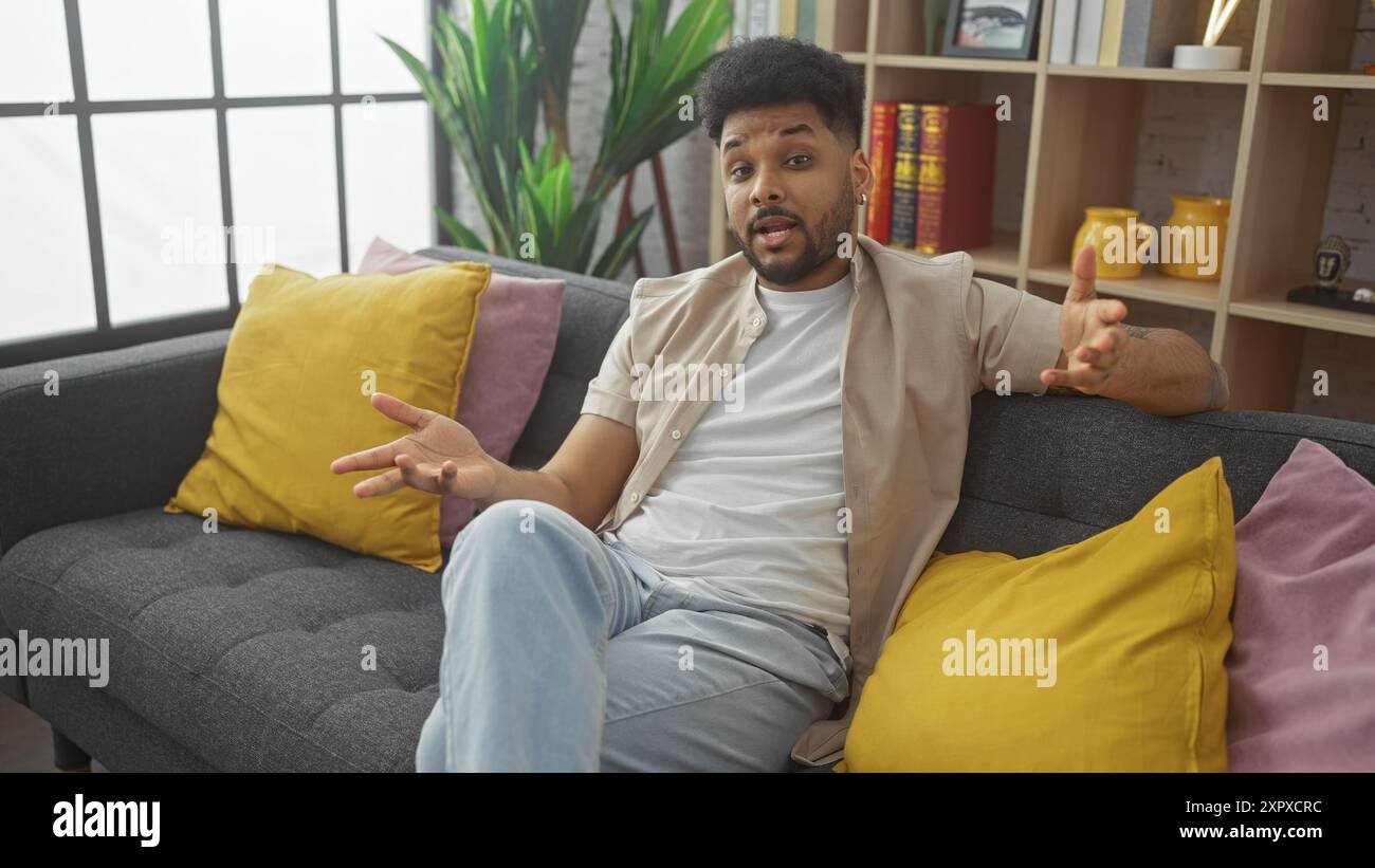 An african american man sitting casually on a couch in a cozy living ...