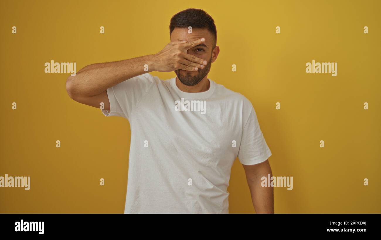 A handsome young hispanic man with a beard in a white shirt poses over ...