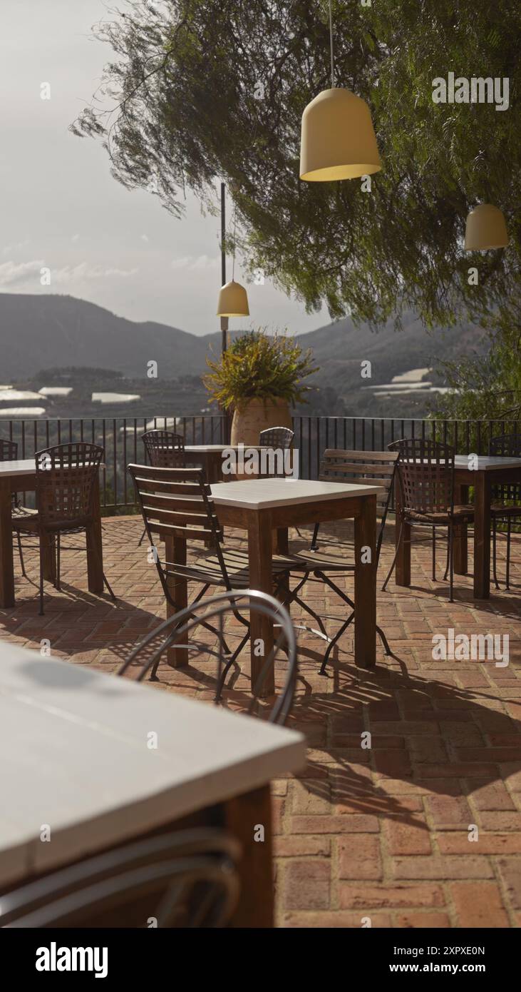 Outdoor cafe terrace with empty chairs and tables overlooking scenic ...