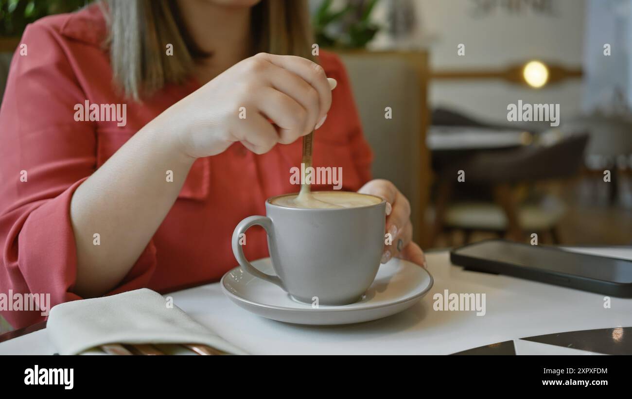 Beautiful woman stirs coffee sitting hi-res stock photography and ...