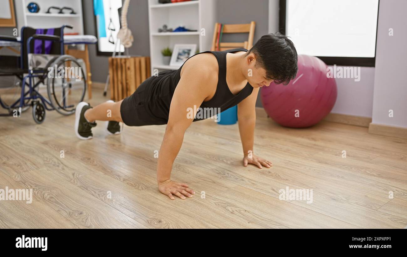 Asian man exercising in a rehabilitation clinic interior with ...