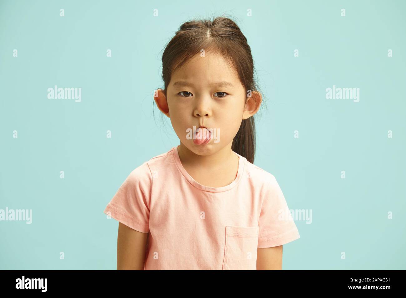 Mischievous Girl Making a Face, Sticking Out Her Tongue Showing to ...