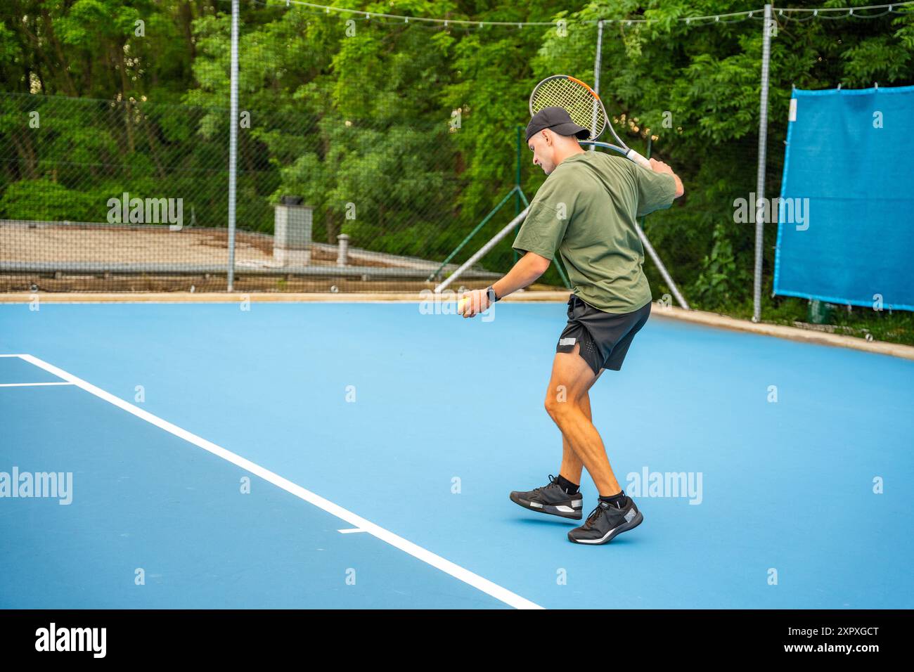 Professional male tennis player playing the tennis on outside court ...