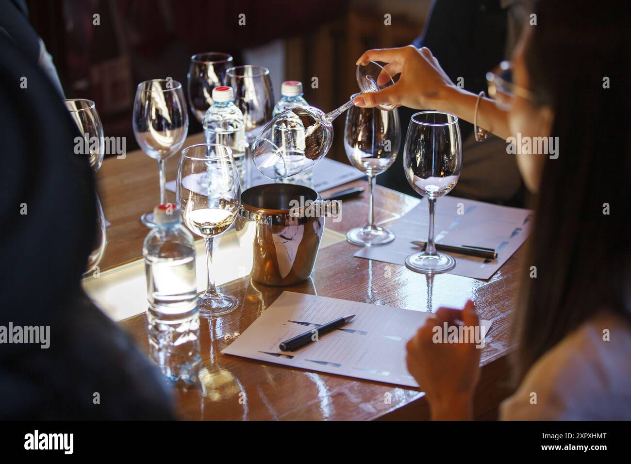 Professional Female Cavist Discarding White Wine in Spittoon During ...