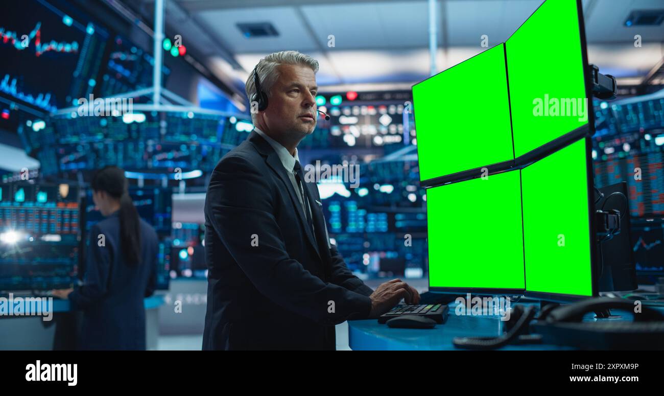 Adult Stock Exchange Broker Working on a Desktop Computer with Green ...