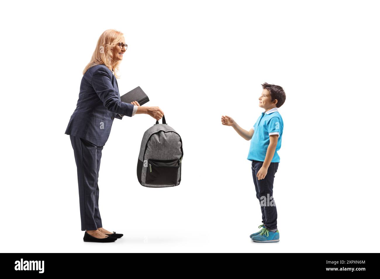 Full length shot of a teacher giving a backpack to a boy isolated on ...