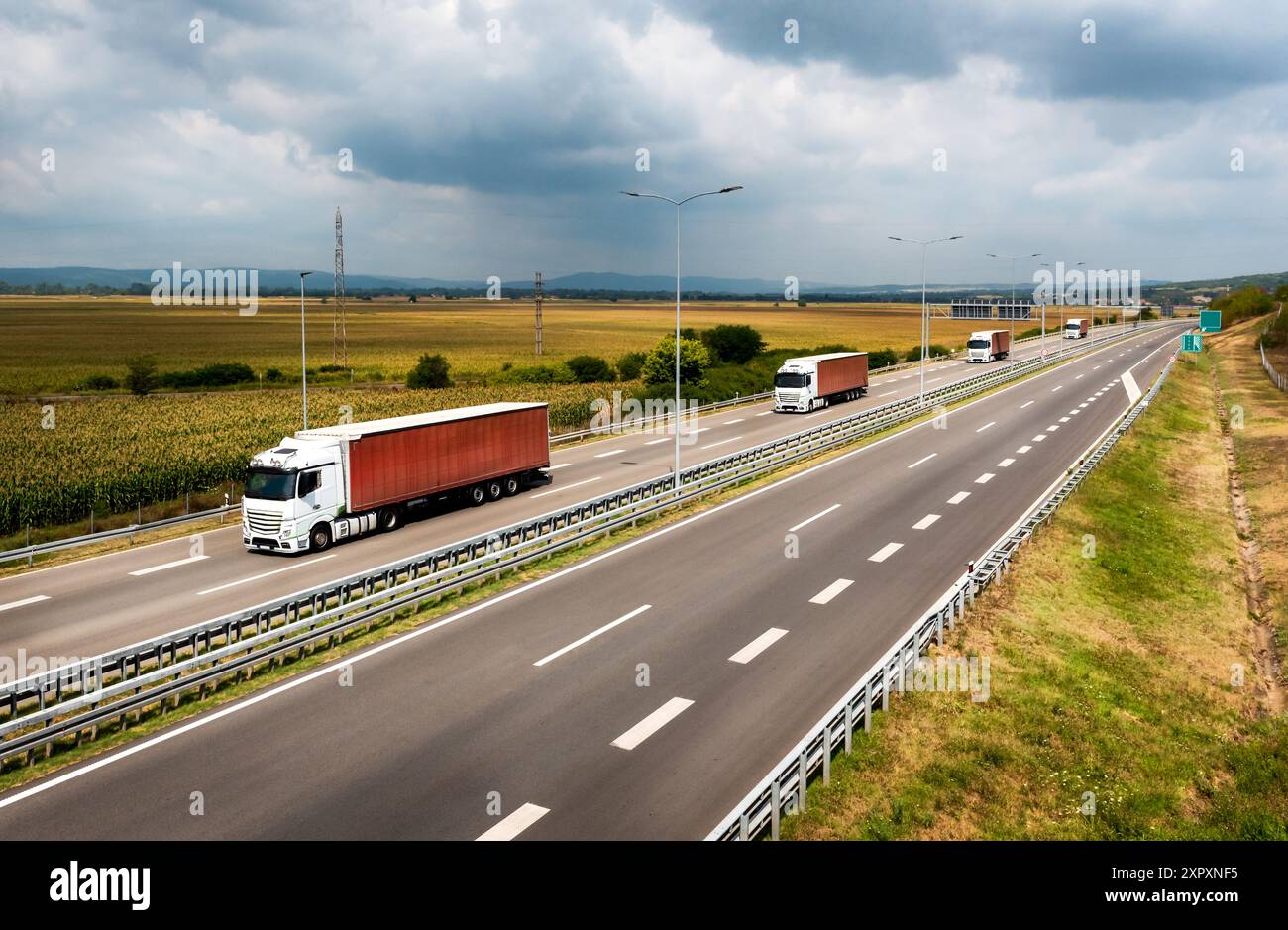 Highway transportation scene with Convoy of white transportation trucks ...