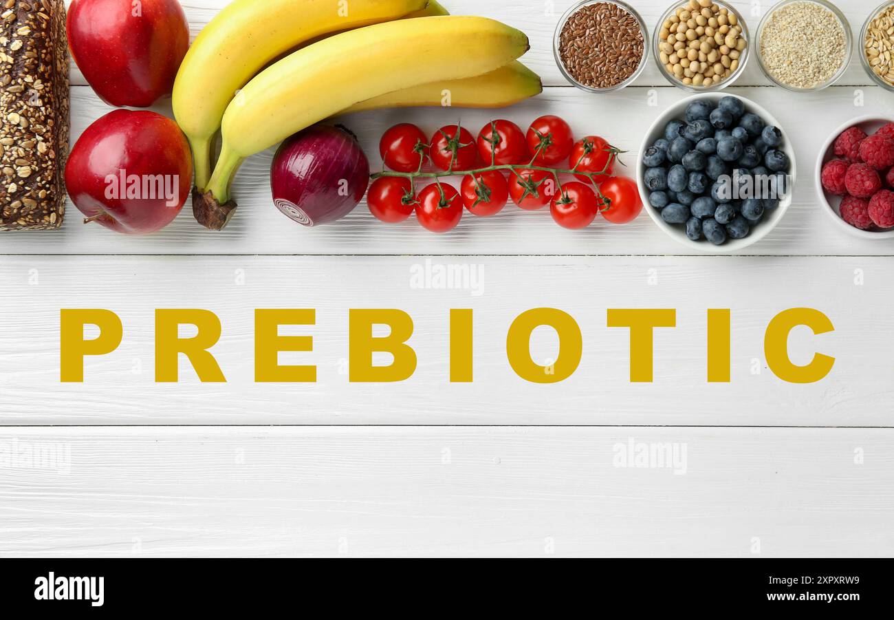 Word Prebiotic and different gut-healthy foods on white wooden table ...