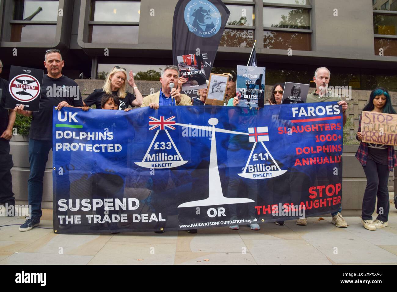 Protesters hold a banner calling on the UK to suspend trade deals with ...