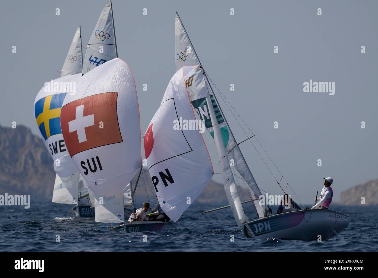 A fleet of boats compete in the 470 mixed dinghy medal race during the ...