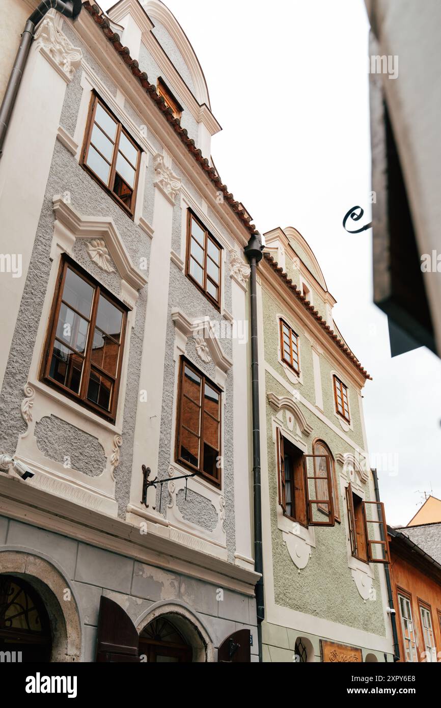 Worn facades of historic buildings rise above a narrow cobblestone ...