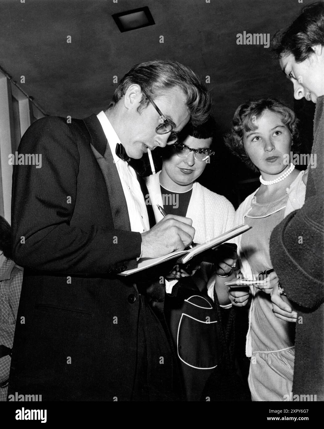 JAMES DEAN candid photo wearing glasses while signing autographs for ...