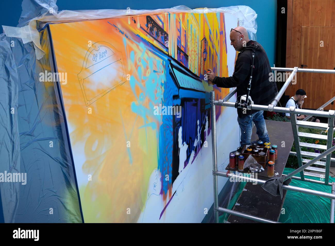 French street artist Marko93 sprays paint on a piece of artwork, during ...