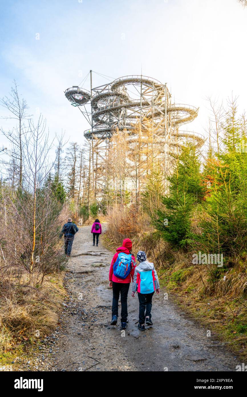 A group of people hike on a trail leading to the Sky Walk Tower in ...