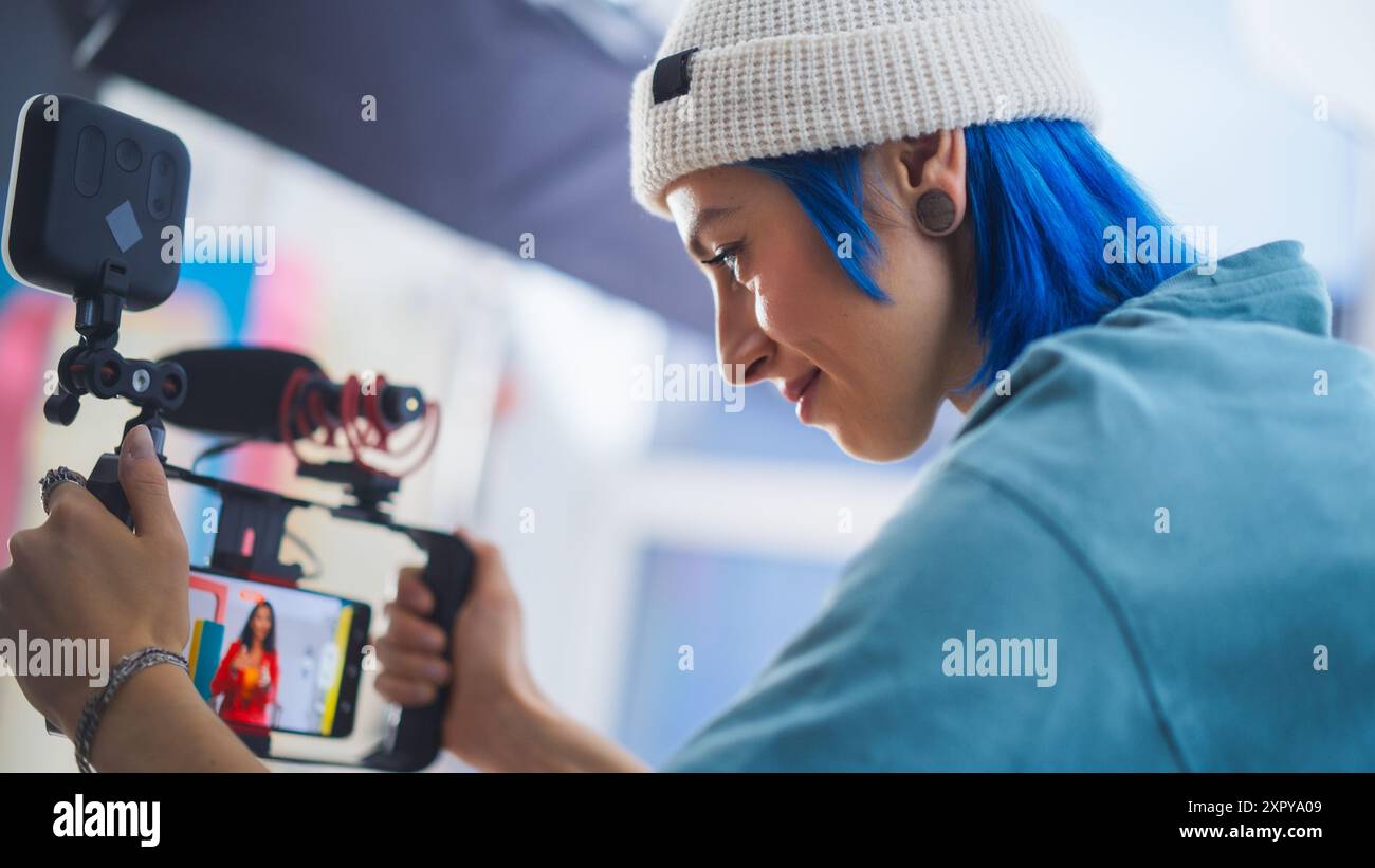 Young Caucasian Female Cinematographer With Blue Hair Adjusts Camera ...