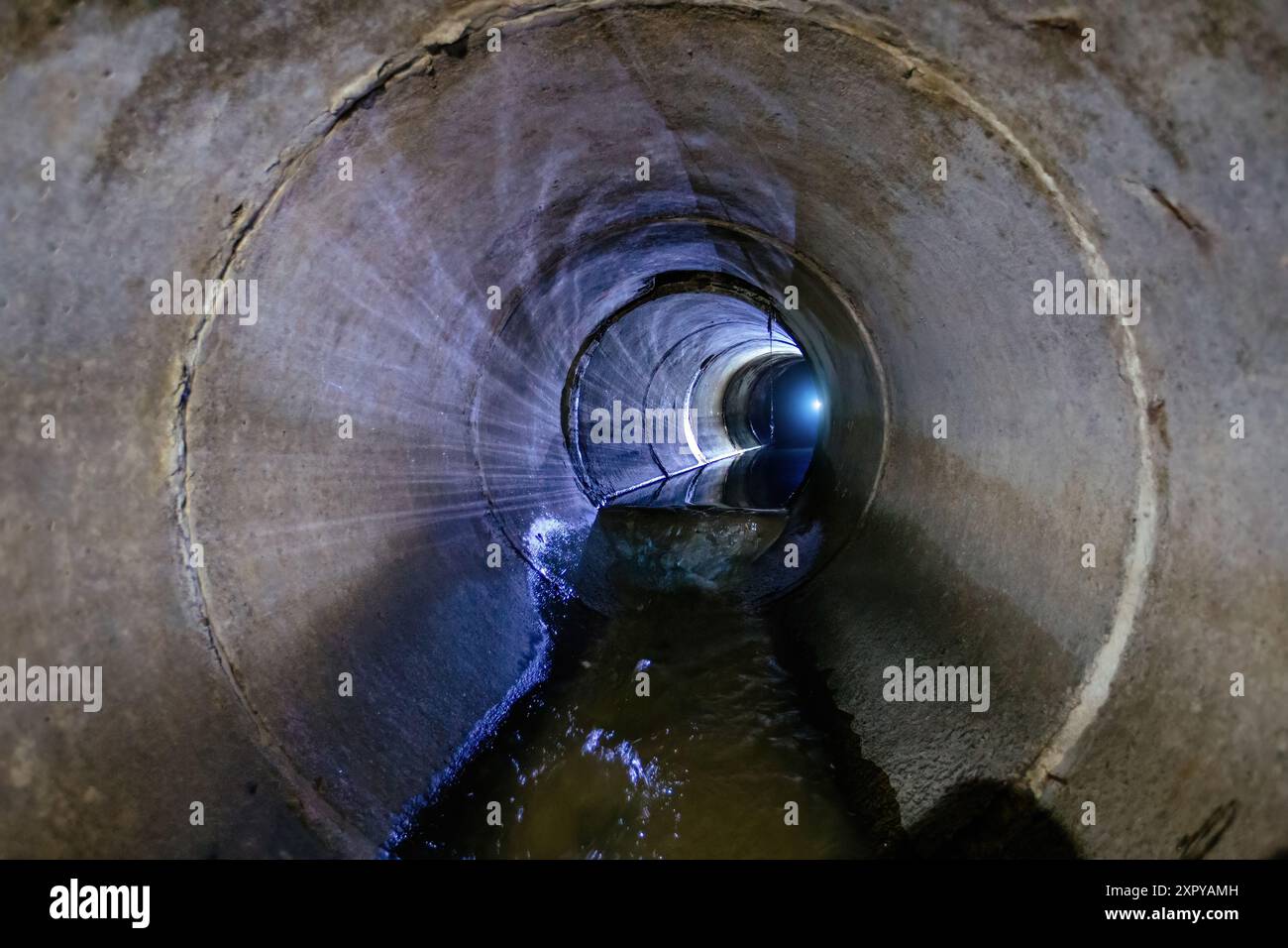 Dirty sewage flowing in round underground sewer tunnel Stock Photo - Alamy