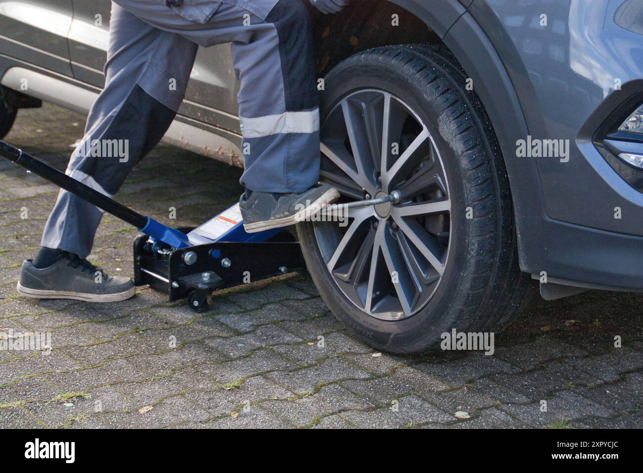 Stuck wheel nuts are loosened with the help of the foot Stock Photo - Alamy