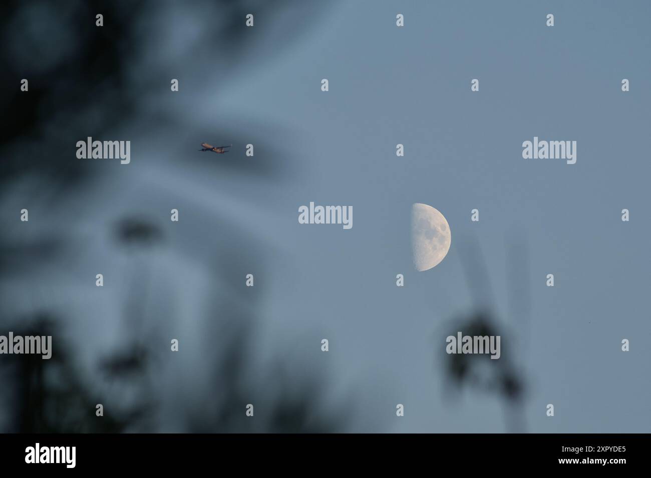 the crescent moon in the sky with an airplane to the left of the moon ...