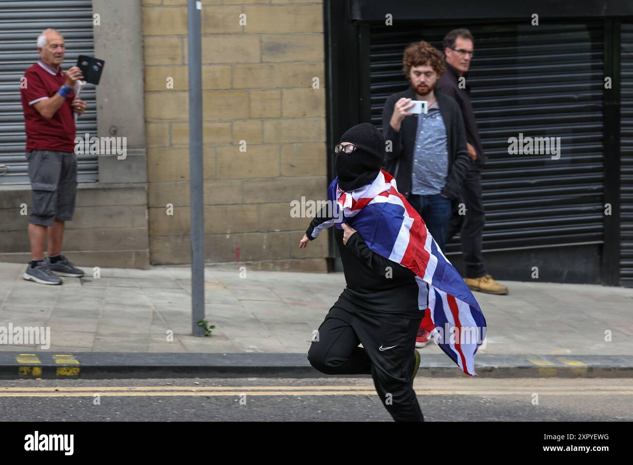 A protestor with a Union Jack flag around them during an anti-racism ...