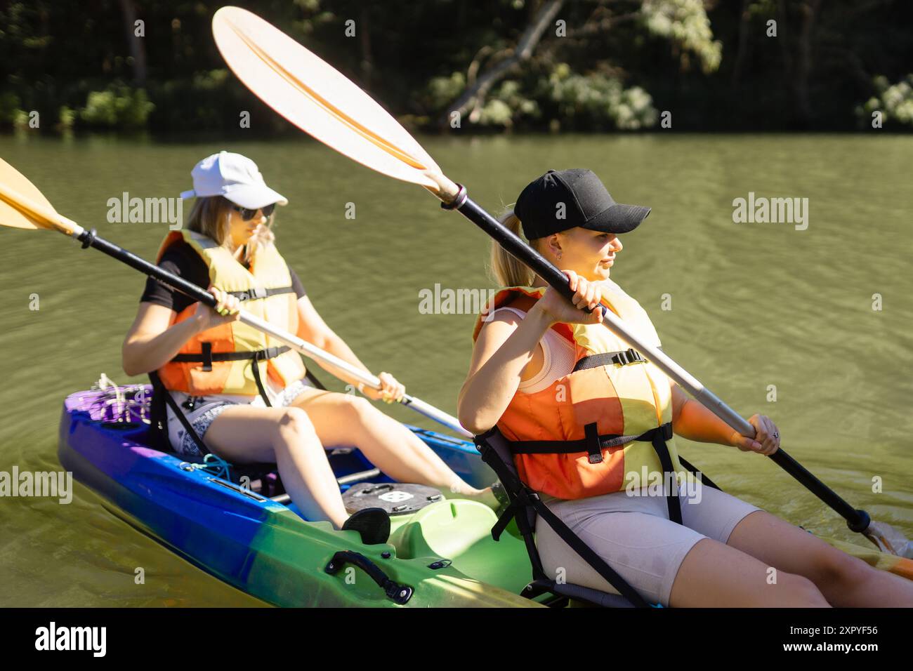 Two young women floating and smiling in a kayak on the river Stock ...