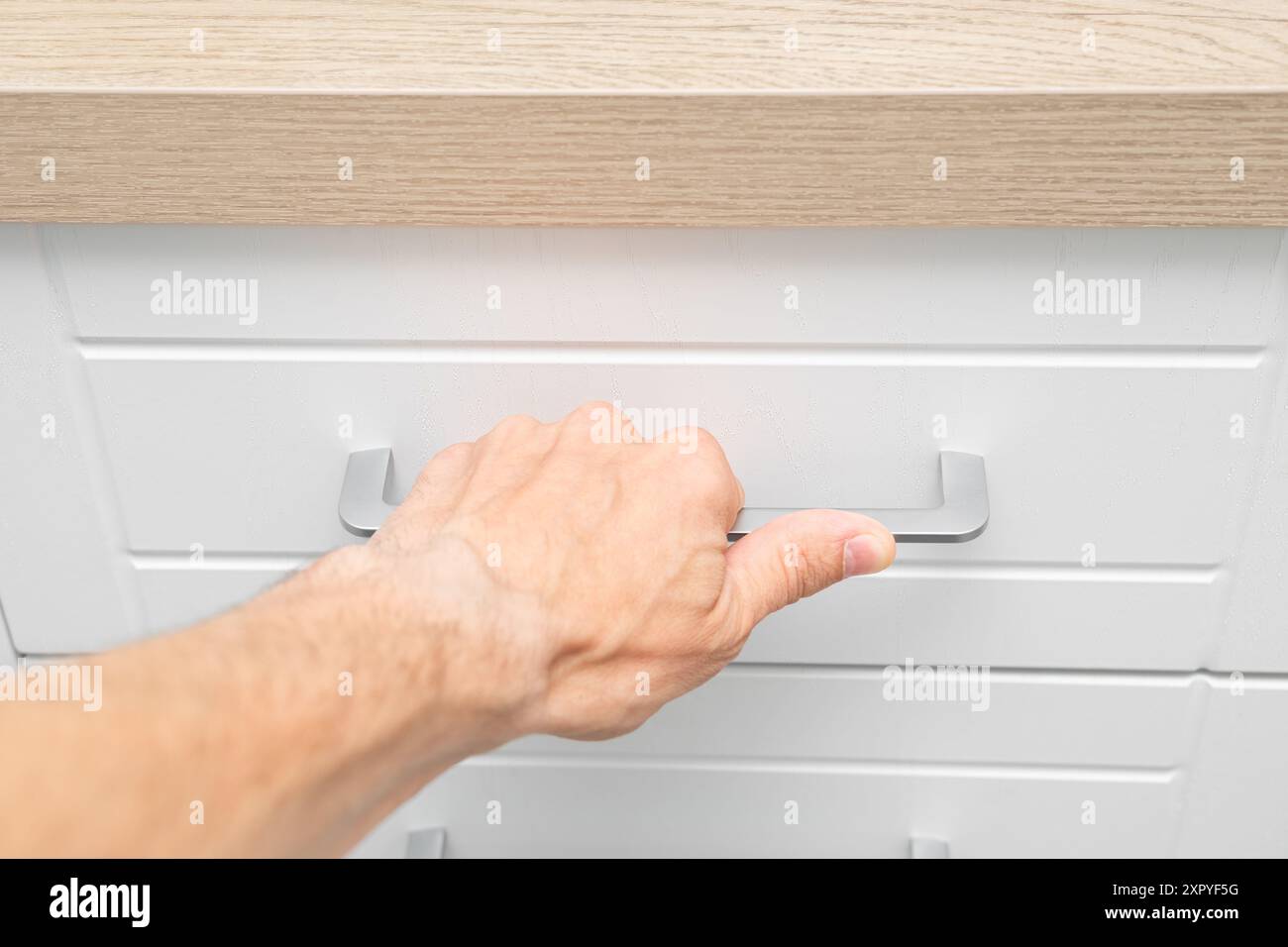 man's hand opens a kitchen cabinet drawer. man opens drawer Stock Photo ...