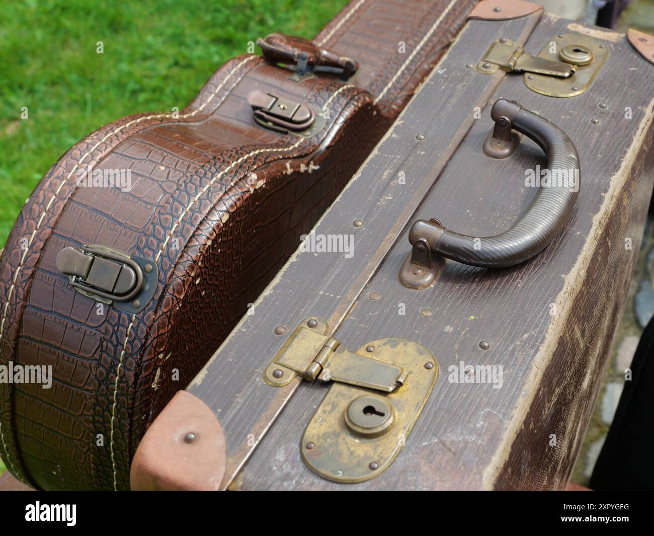 Close-up of an antique travel trunk and a guitar case with a snakeskin ...