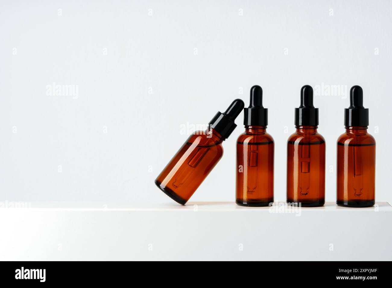 Row of various brown glass dropper bottles isolated on white background ...