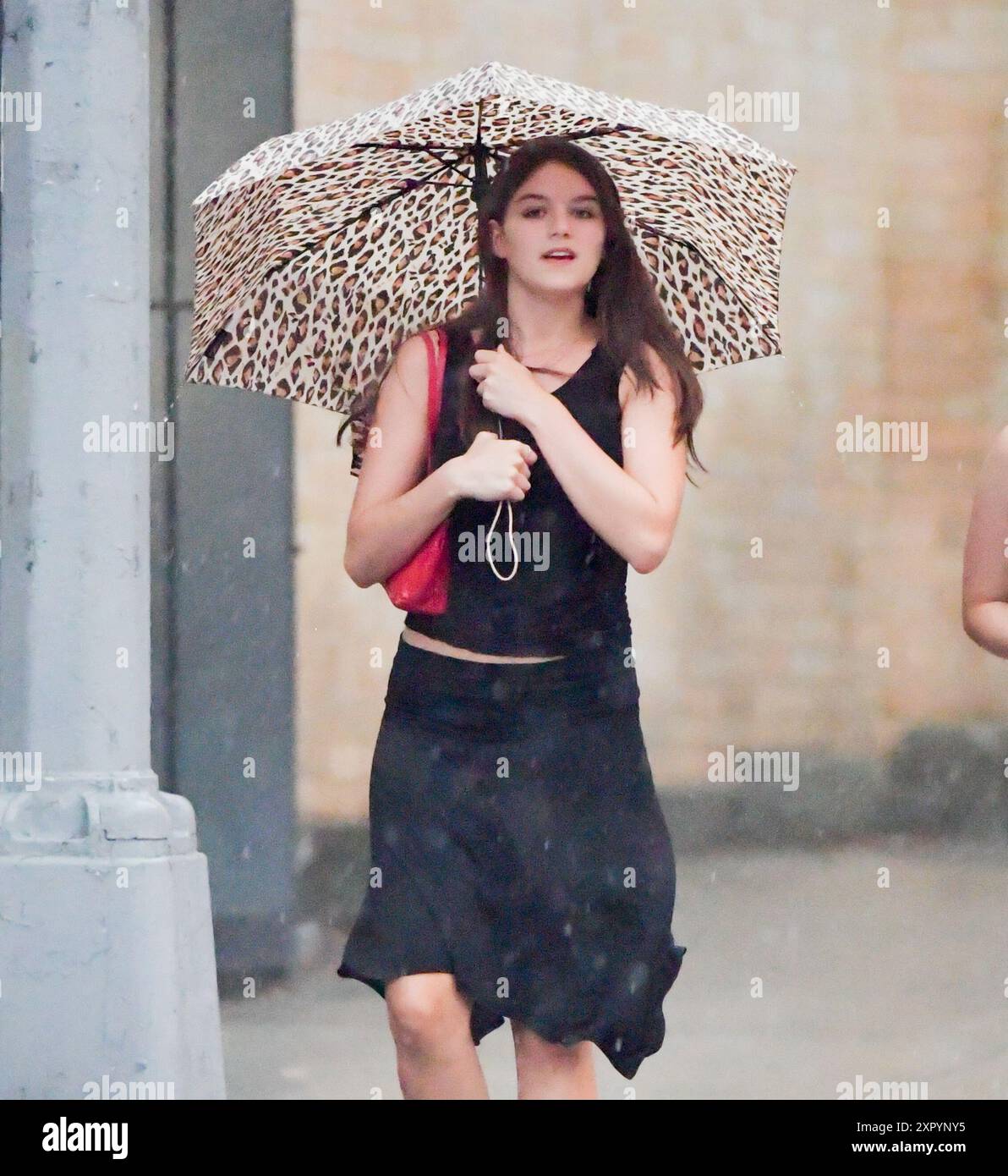 Suri Cruise hides from the rain under an umbrella as she goes for a ...