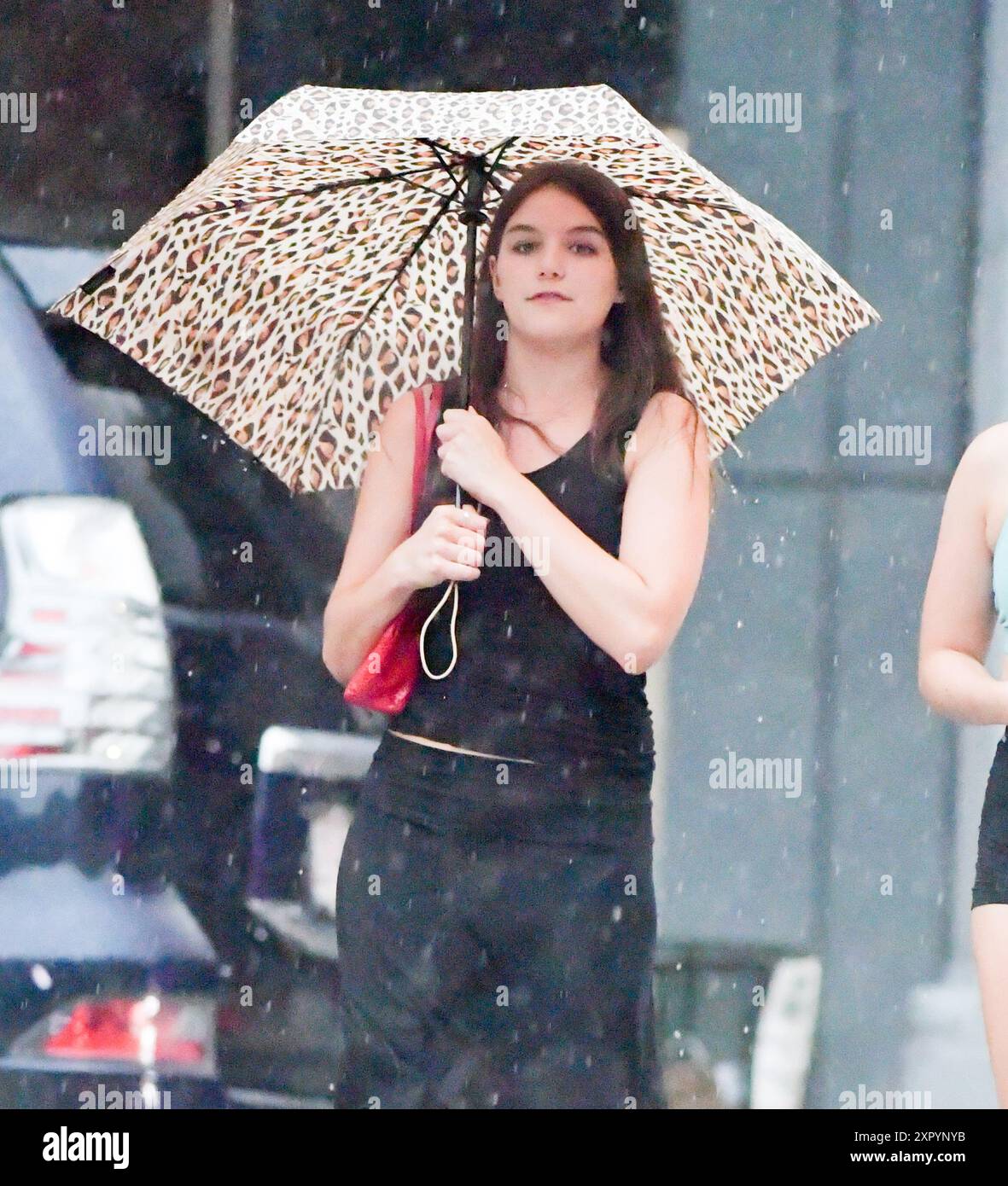 Suri Cruise hides from the rain under an umbrella as she goes for a ...